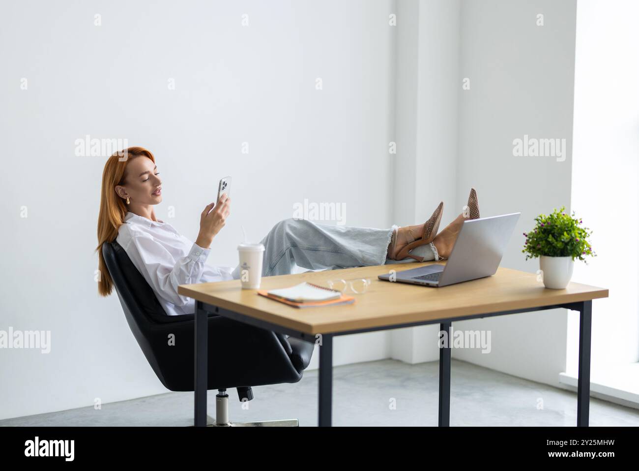 Attractive woman stretching body and relaxing at the office with legs ...