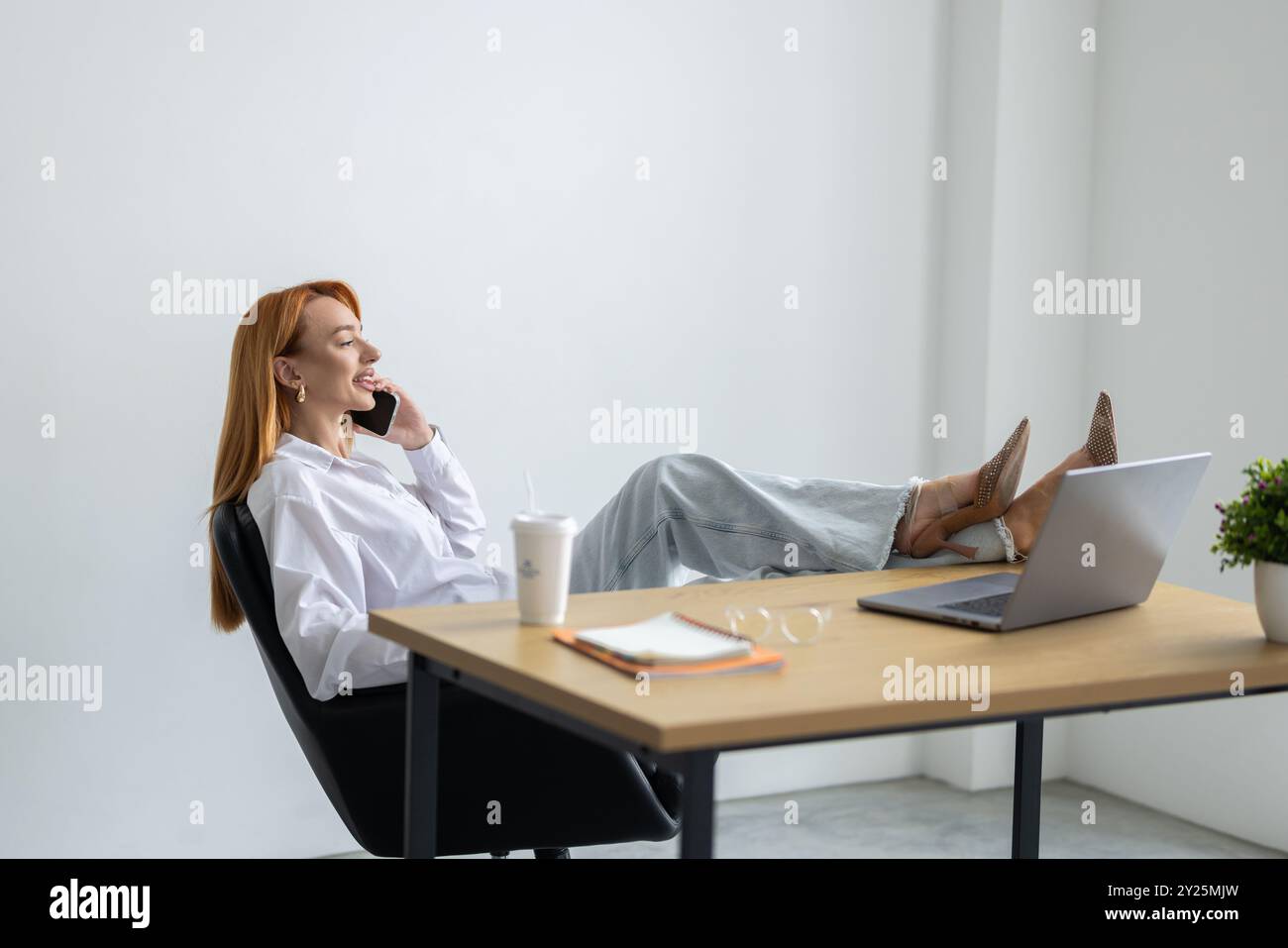 Attractive woman stretching body and relaxing at the office with legs ...