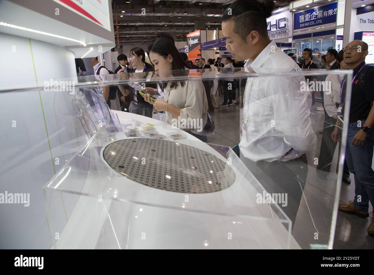 Visitors watch various silicon wafers on display during the SEMICON ...