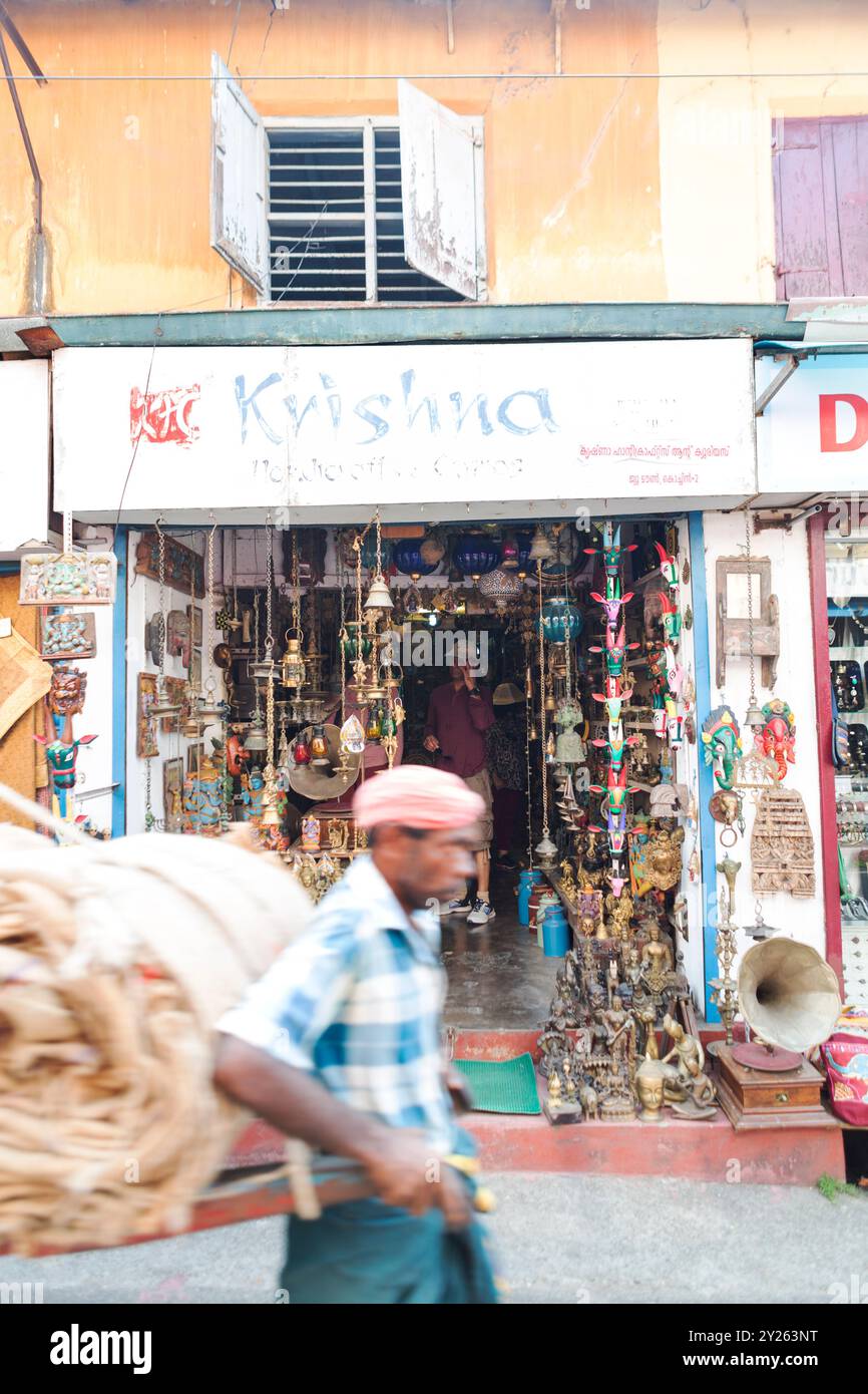 India, Kerala, Kochi (Fort Cochin), Indian man with wheelbarrow walks ...