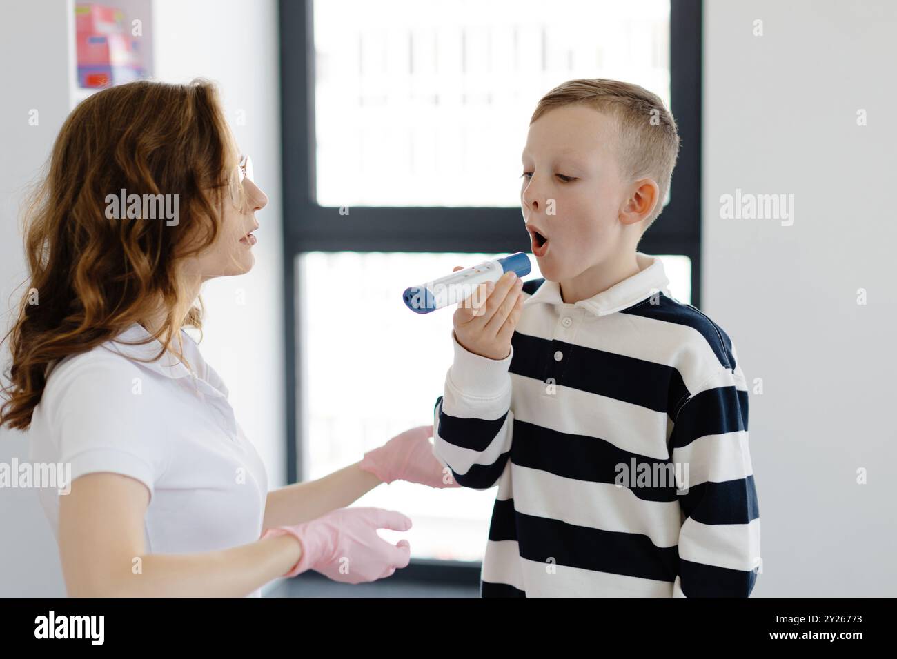 Pediatric pulmonologist helping boy with peak flow meter. Pulmonologist ...