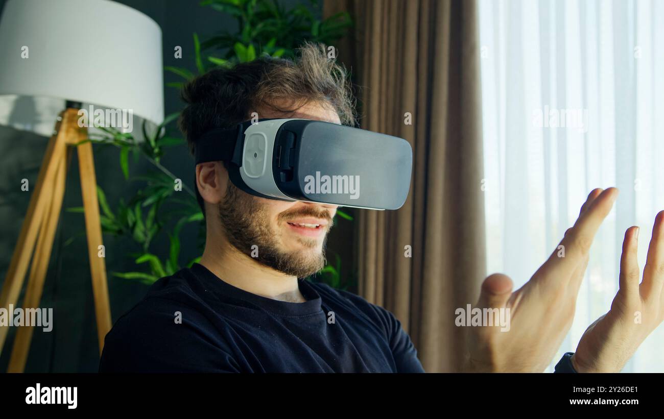 man immersed in a virtual reality experience wears a VR headset, interact with the digital ...