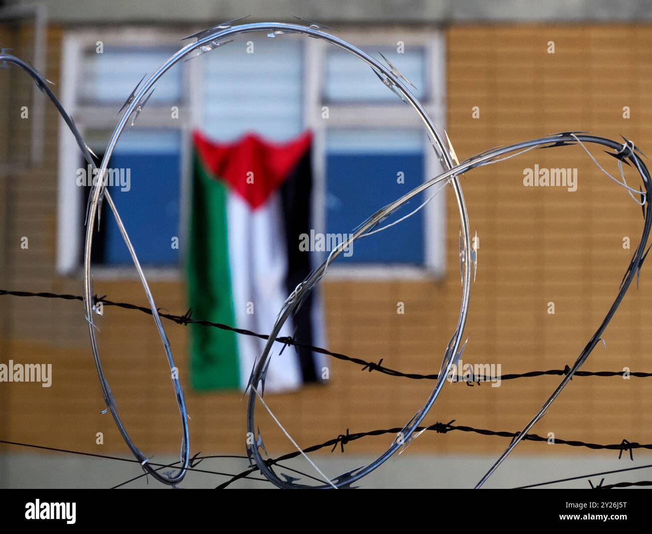 detail of palestine flag hanged on a window behind barbed wires Stock ...