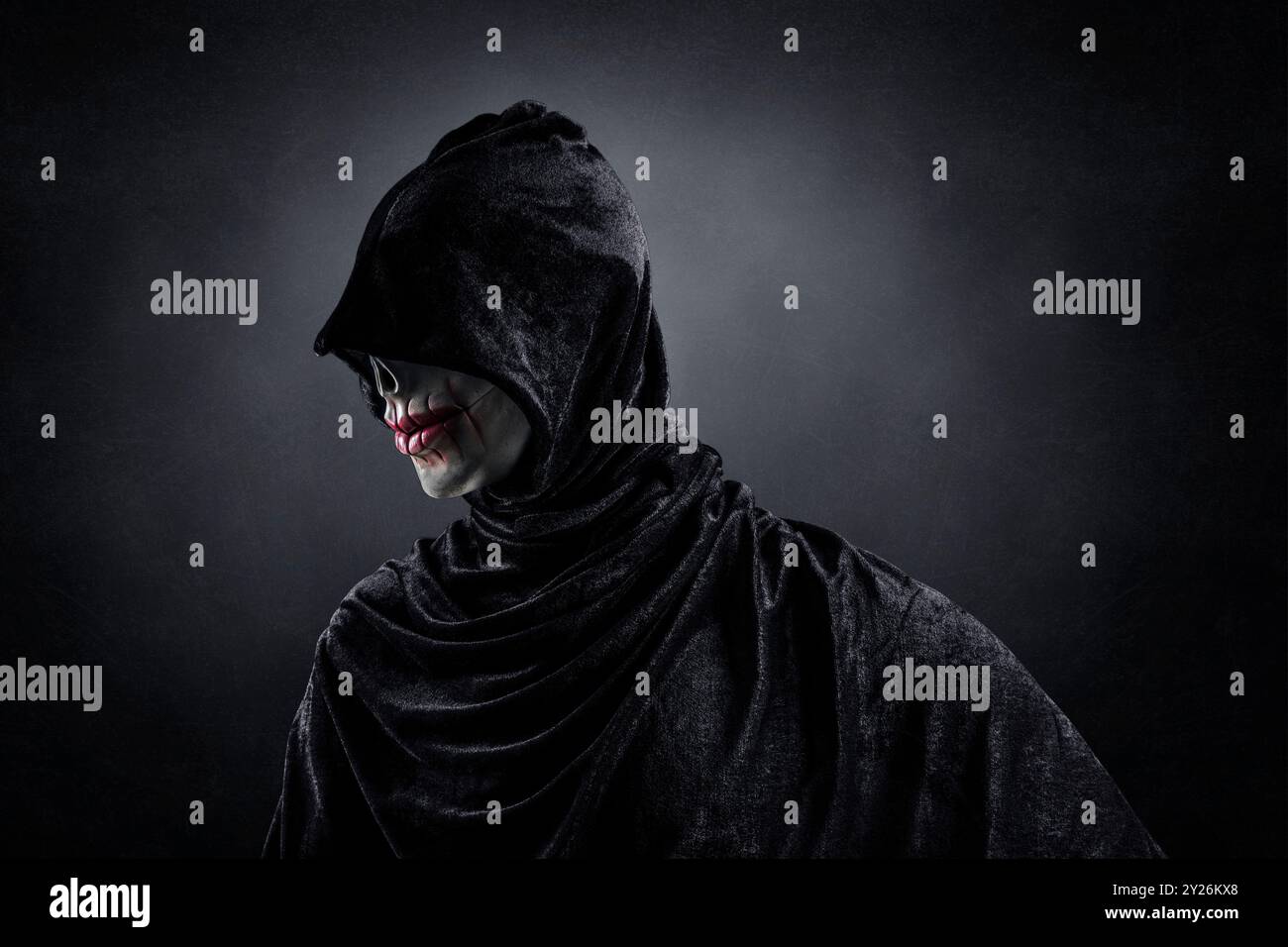 Scary figure with hooded cloak in the dark Stock Photo - Alamy