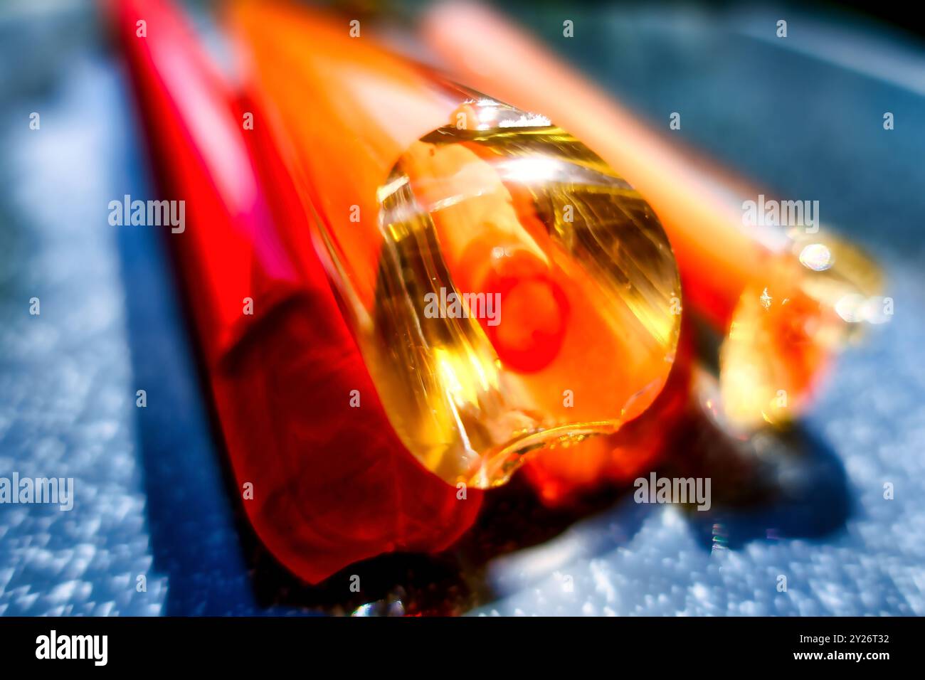 Intentionally blurred close-up view of a colored glass rod with core ...