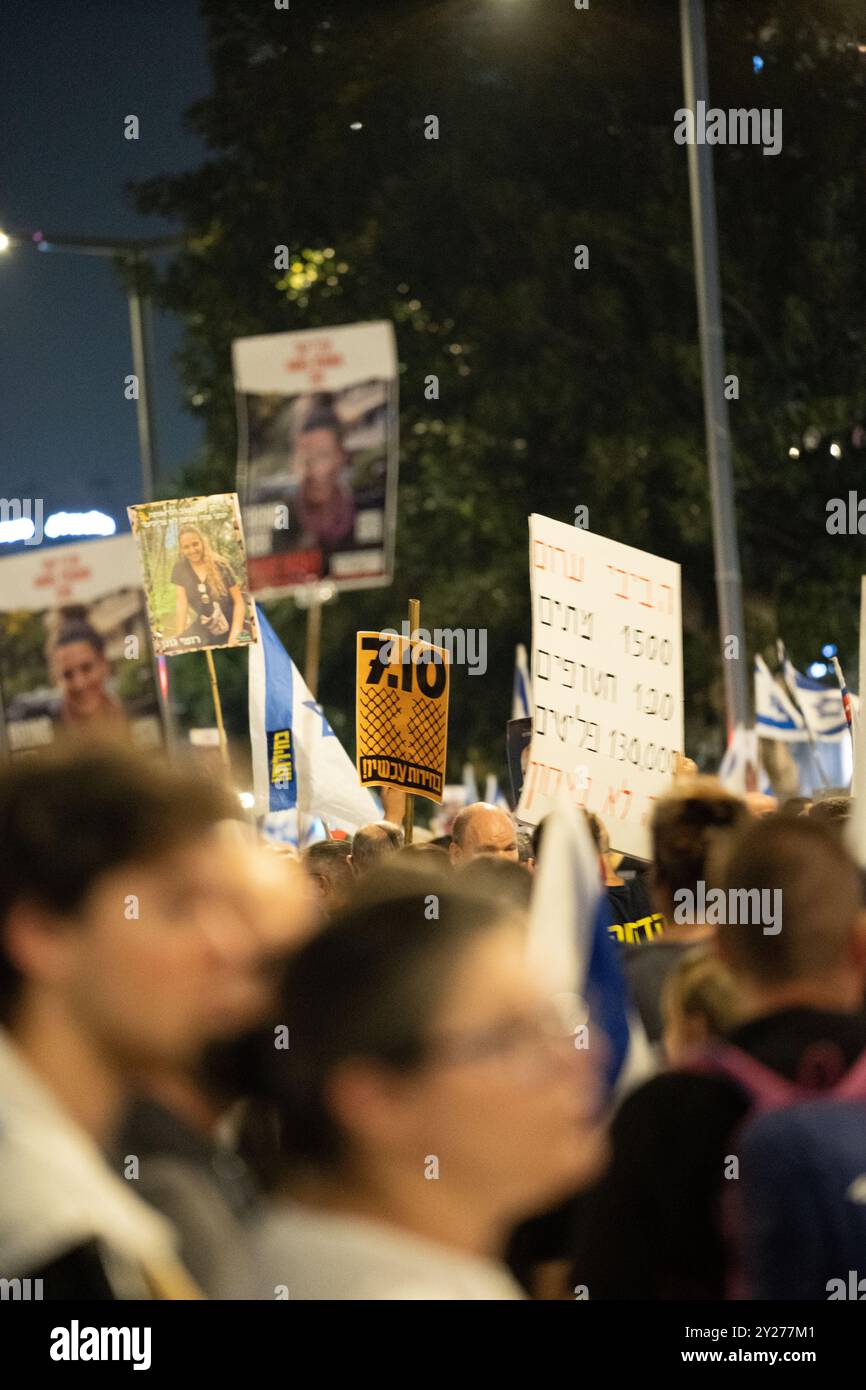 Protesters hold signs featuring hostage photos and anti-government ...