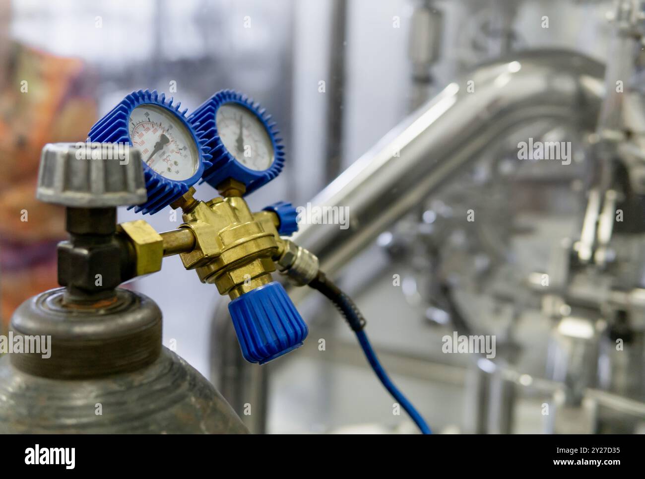 A gas regulator attached to a high-pressure cylinder. The regulator has ...