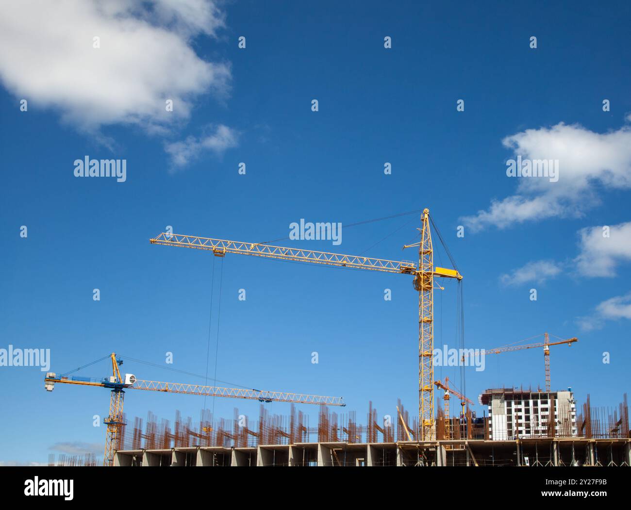Construction site with multiple tall cranes working on building a high ...