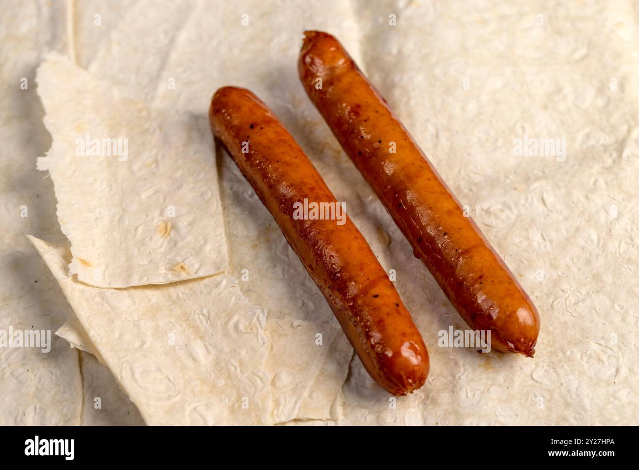 inverted sausages lying on wheat pita bread, cooked pork sausages on ...