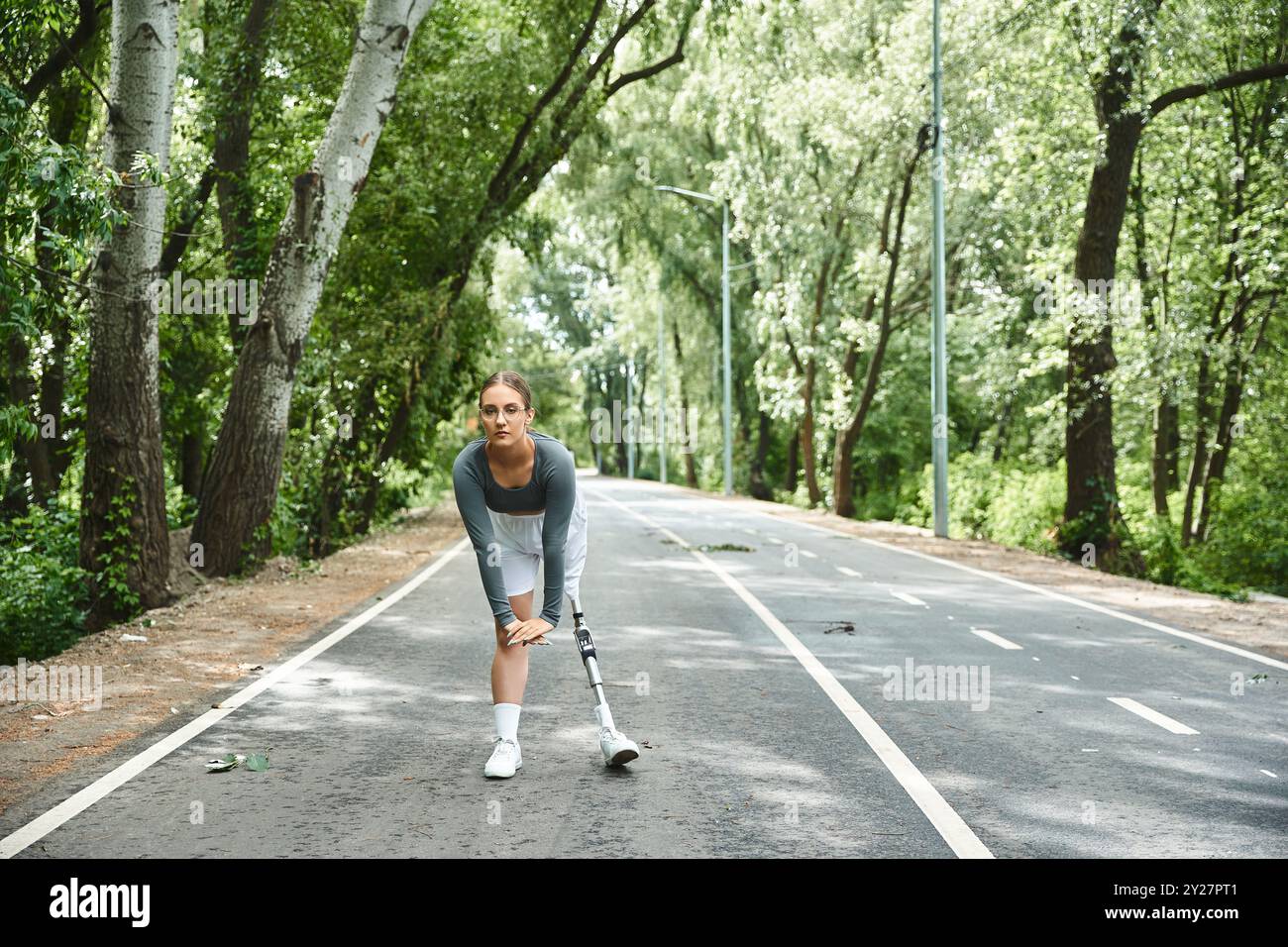 A determined young woman exercises outdoors, showcasing strength with a ...
