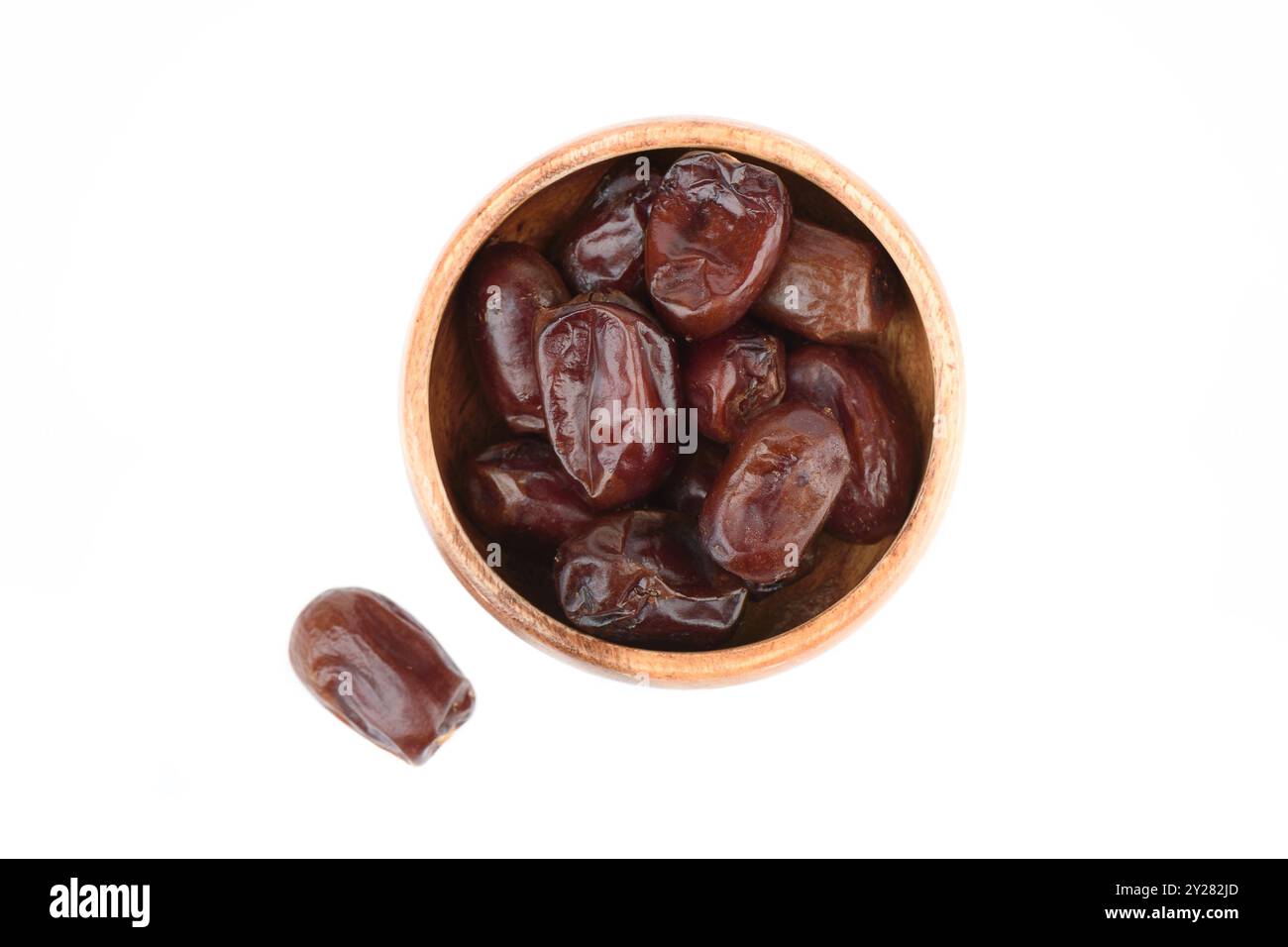 Top view of dehydrated dates fruits in wooden bowl on white background ...