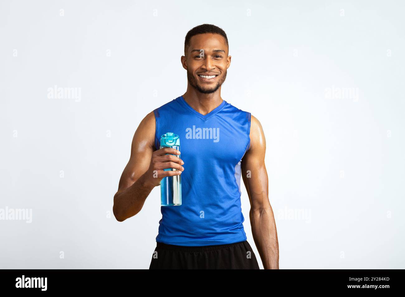 Healthy afro guy with fit body holding bottle of water Stock Photo - Alamy