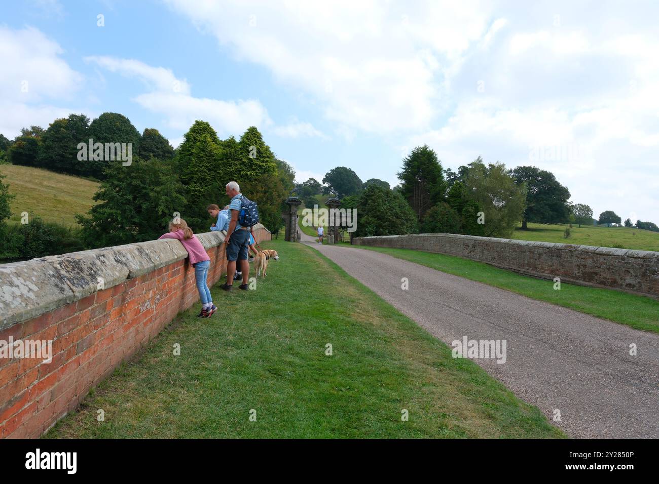 People looking over an old bridge wall Stock Photo - Alamy
