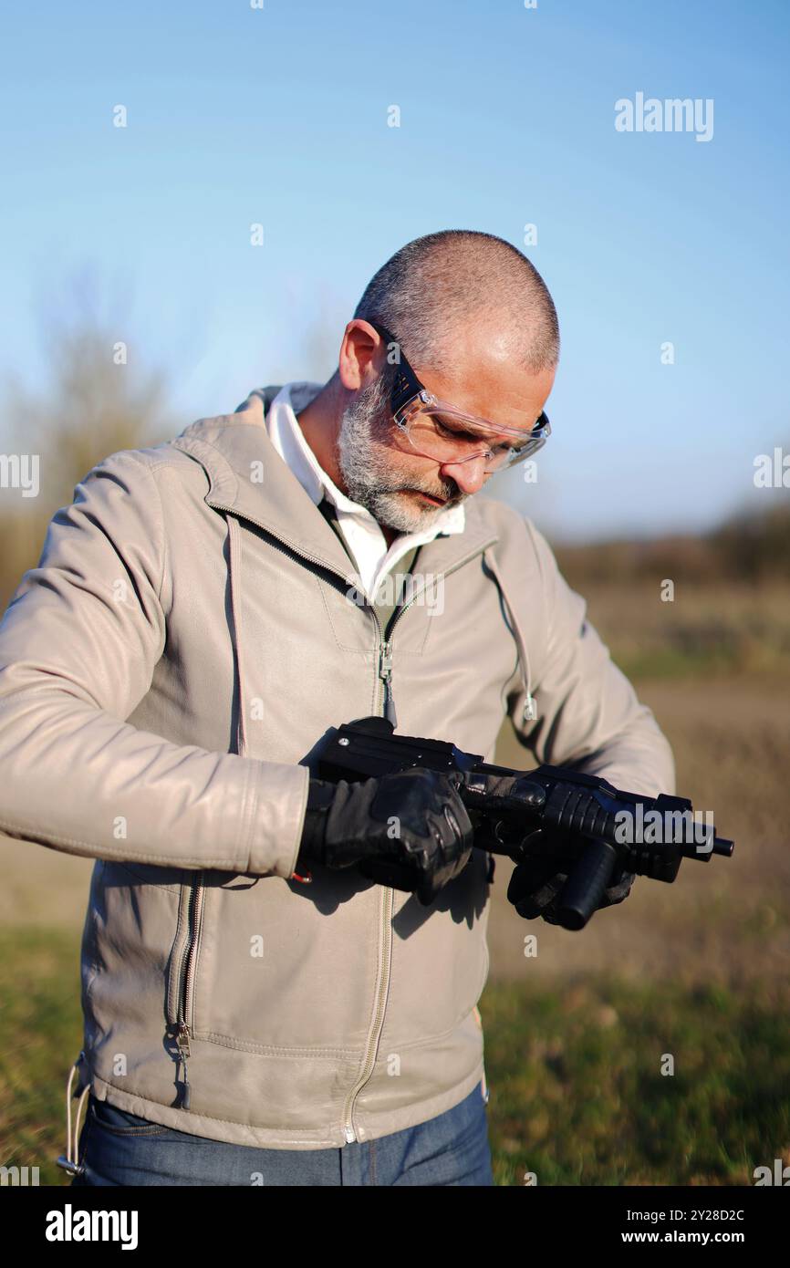 Man with gray jacket shooting black rifle on range clean the gun Stock ...