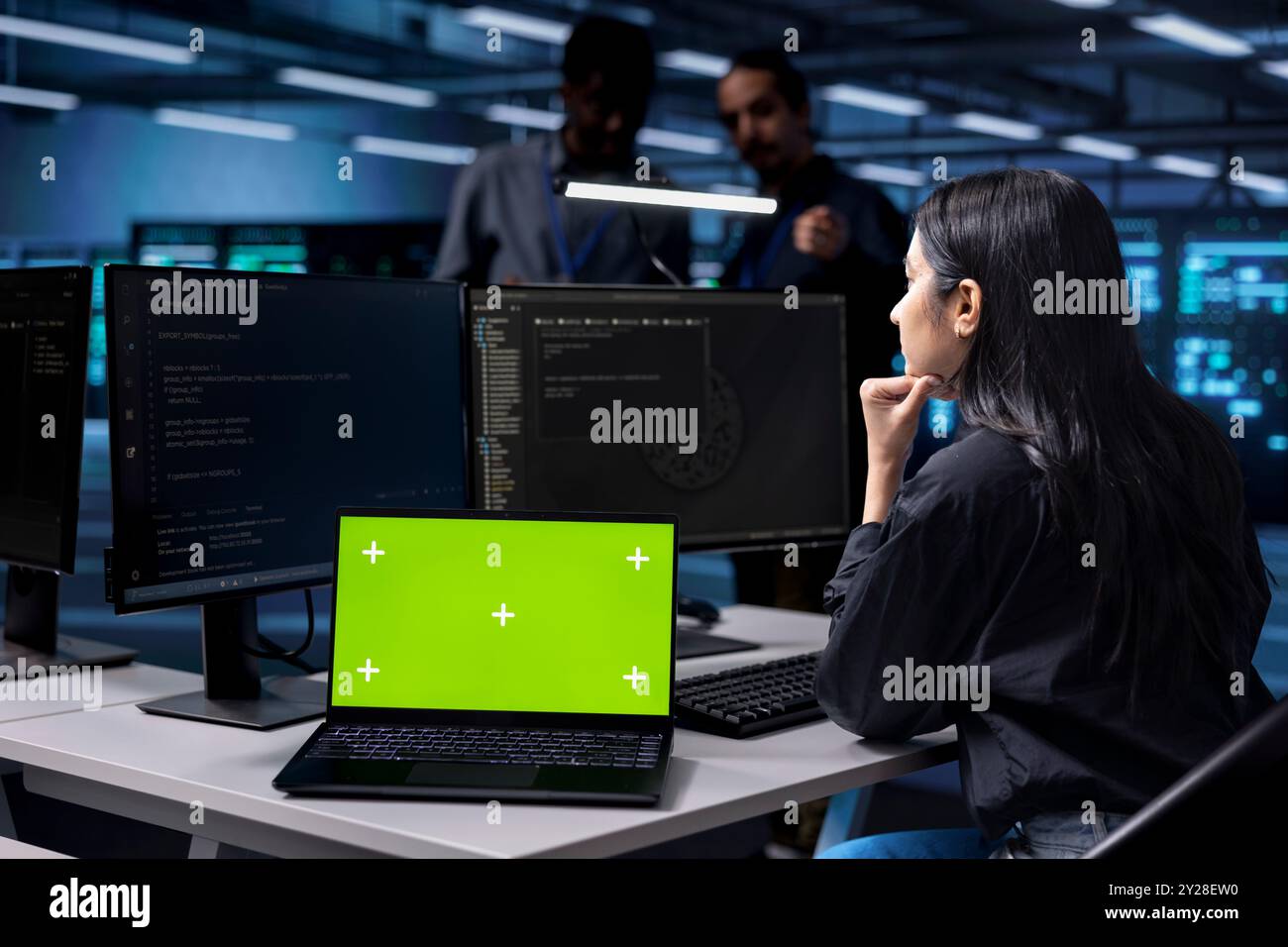 Woman working on laptop with isolated screen monitor in modern data ...