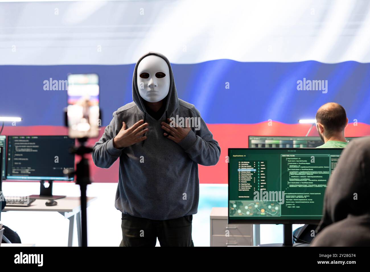 Anonymous hacker expert in a russian hacking high tech office, digital ...
