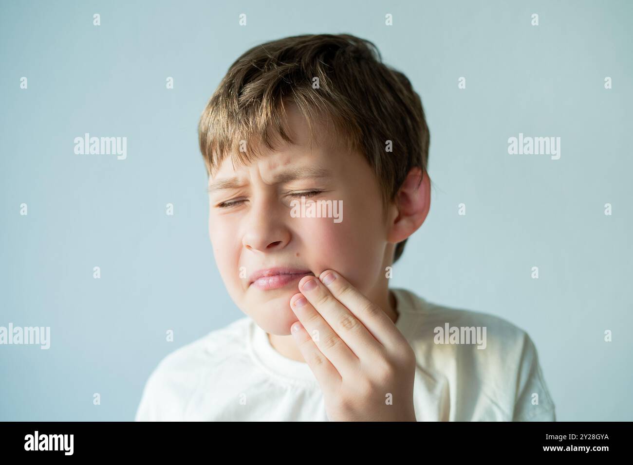 Toothache. 10 year old boy holds his face with his hand Stock Photo - Alamy