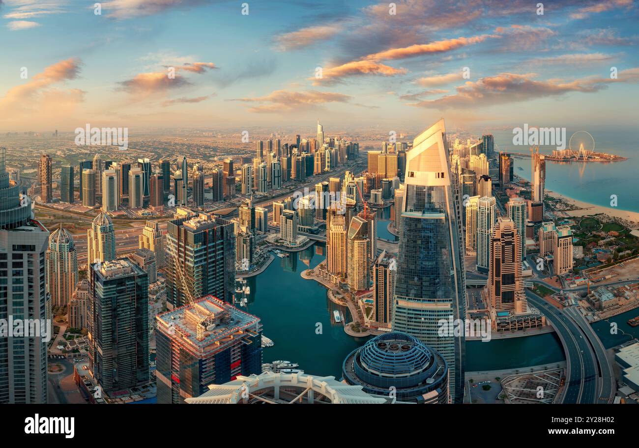View of the Dubai skyline at sunrise from above. Colorful clouds and ...