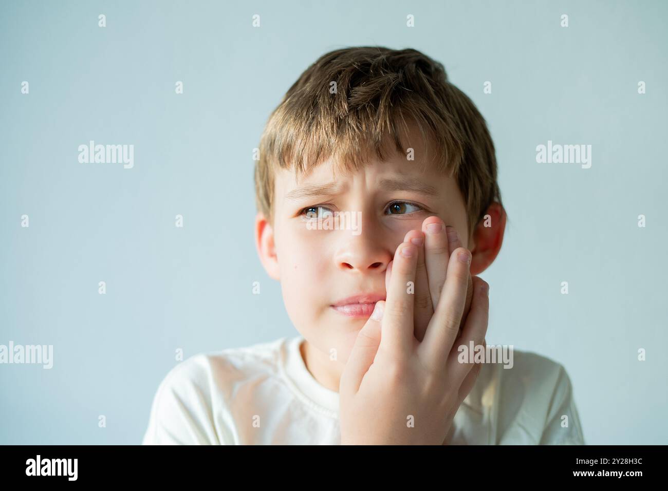 Toothache. 10 year old boy holds his face with his hand Stock Photo - Alamy