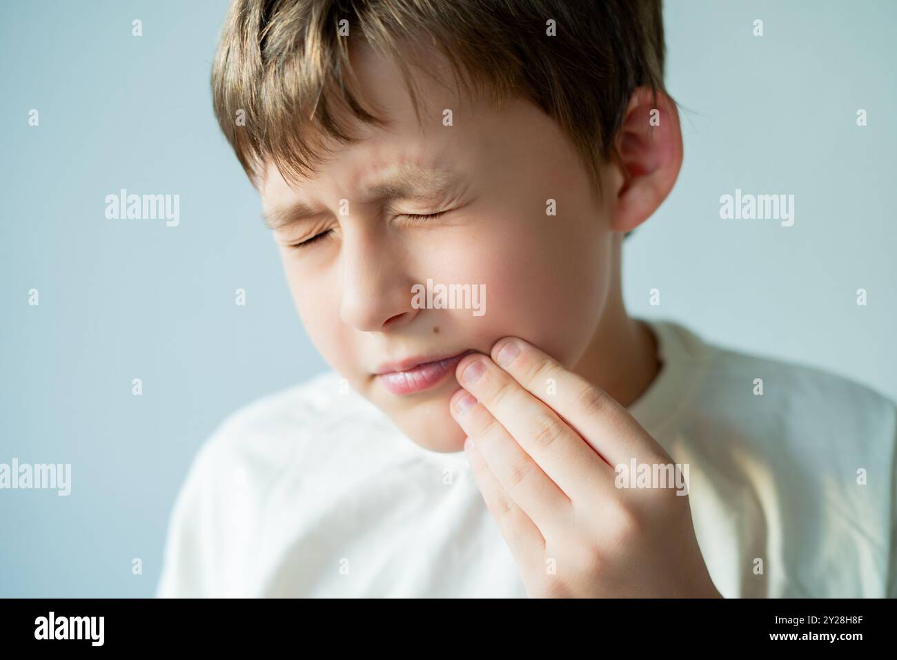 Toothache. 10 year old boy holds his face with his hand Stock Photo - Alamy