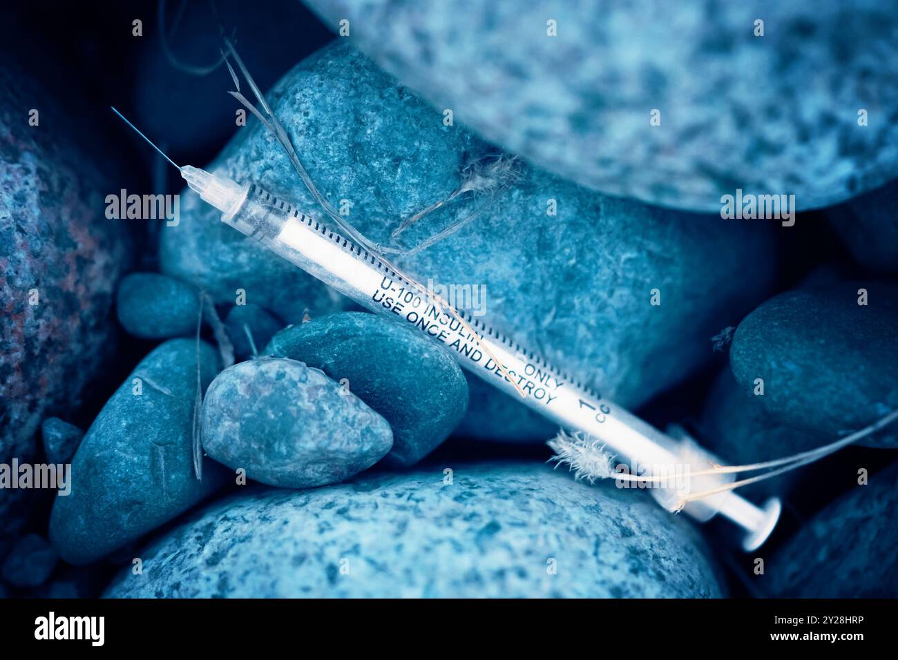 Used syringe lying on the ground Stock Photo - Alamy