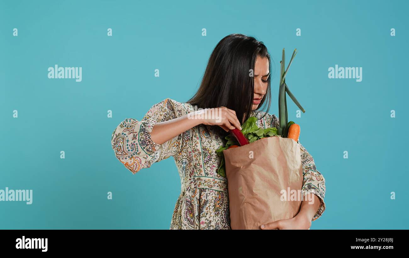 Upset woman frowning after forgetting to buy everything, looking inside ...