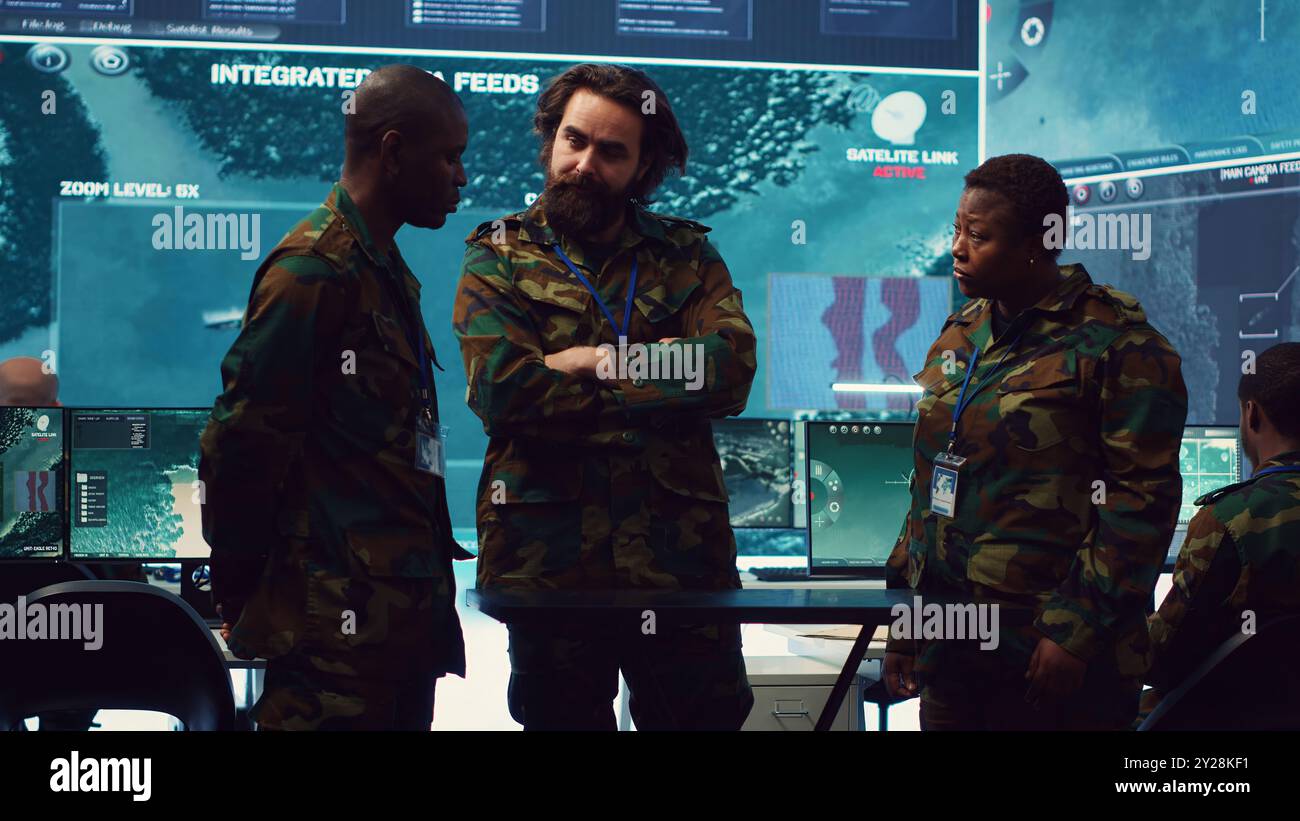 Diverse army officers examining real time data on a hologram, working ...