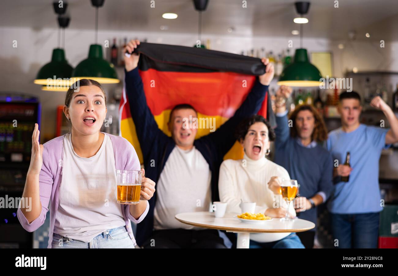 Company of emotional young adult fans supporting German team with state ...