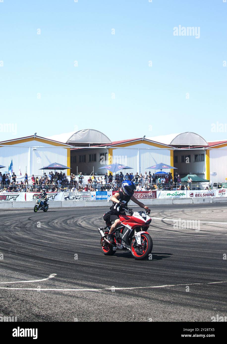 Biker in a black uniform driving a red sports motorcycle on a curvy ...