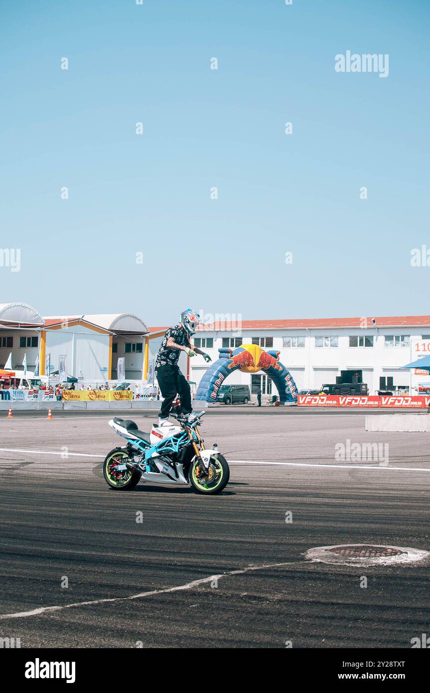 Biker in a black uniform driving a red sports motorcycle on a curvy ...