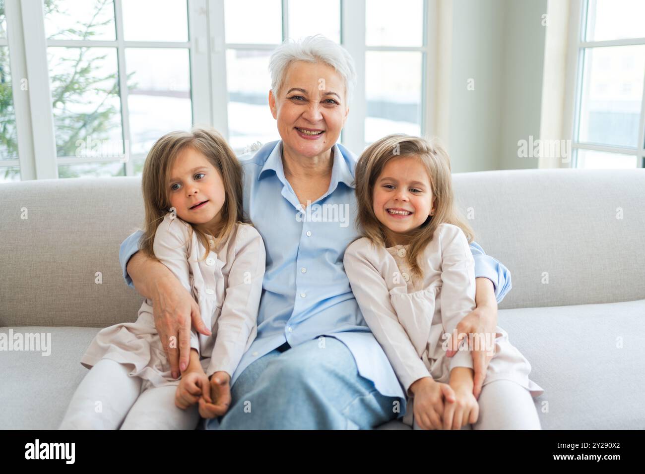 Happy family at home. Two little girls sisters twins grandmother ...