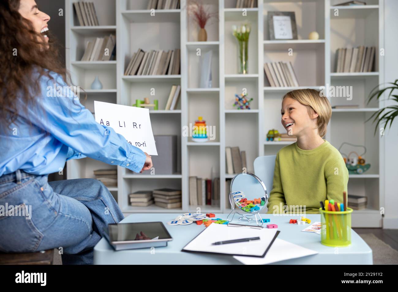 Blonde boy having a speech tutorial with a female speech therapist ...