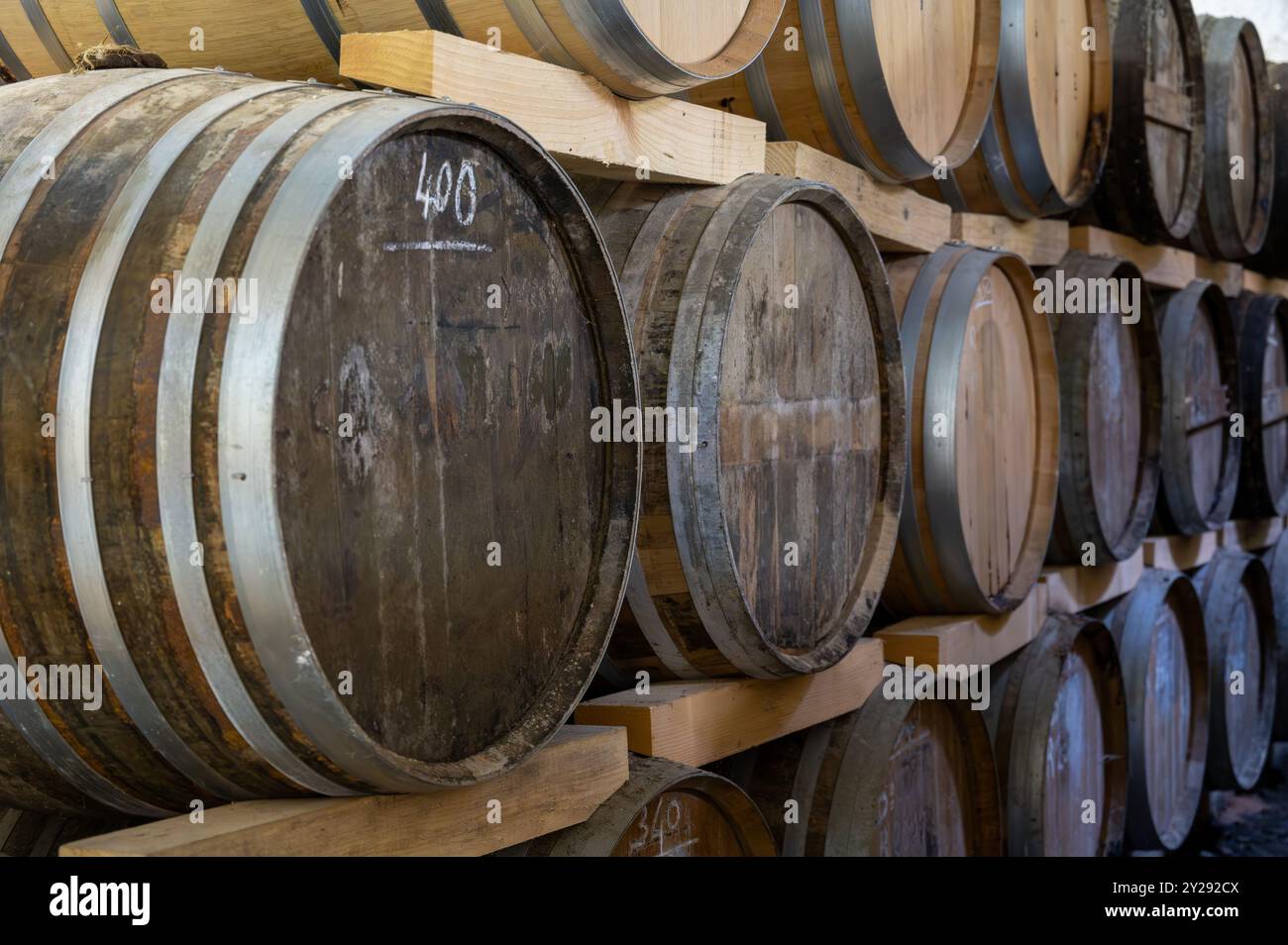 Aging process of cognac spirit in old dark French oak barrels in cool ...