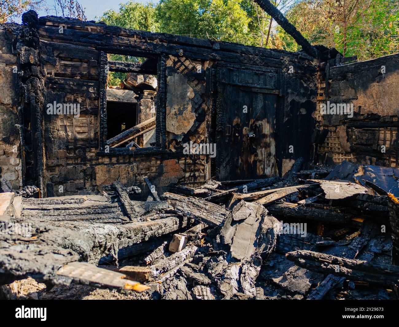 Consequences of fire. Completely burnt wooden house Stock Photo - Alamy