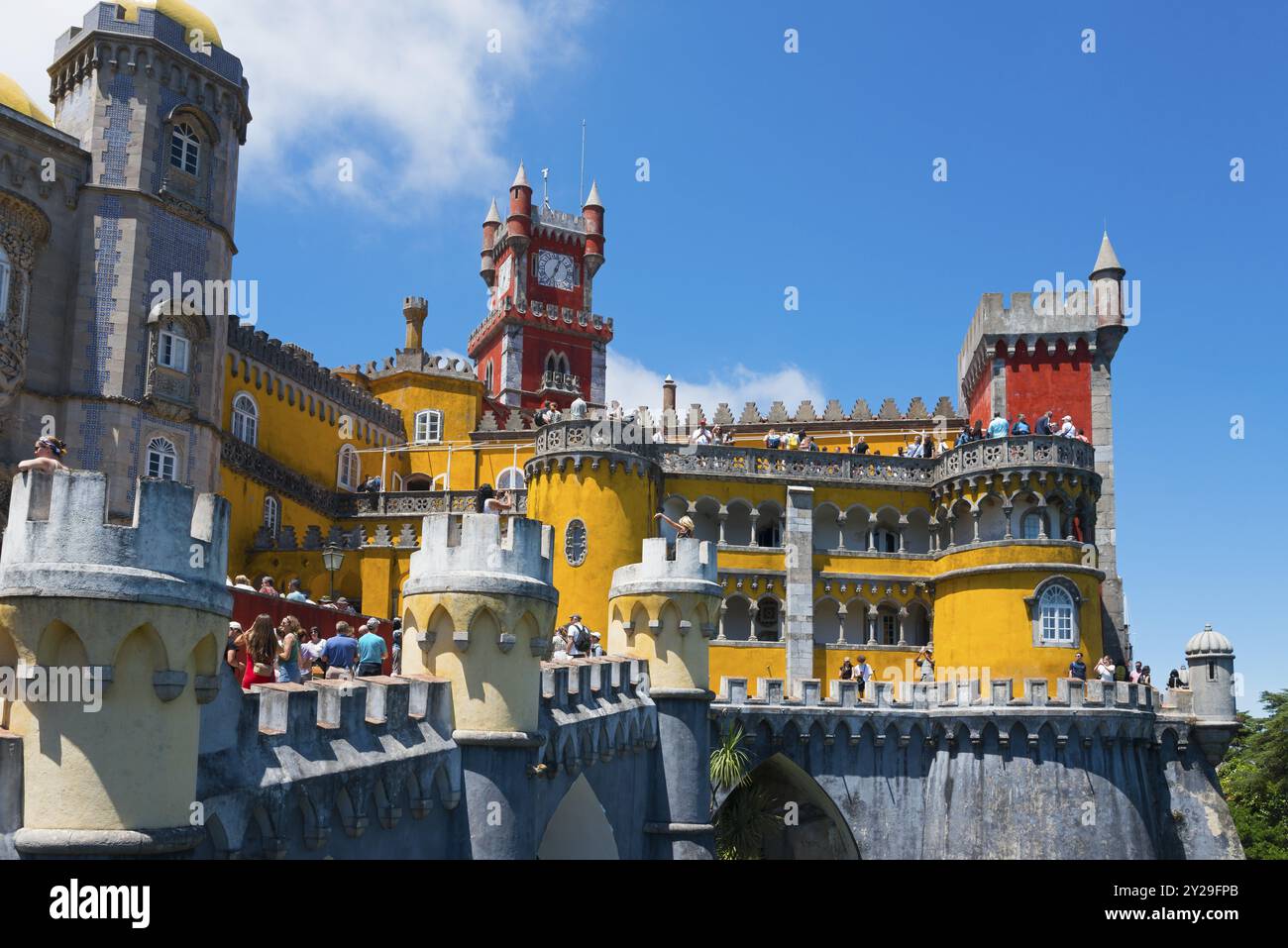 Colourful castle with yellow, red and grey towers, blue sky and ...