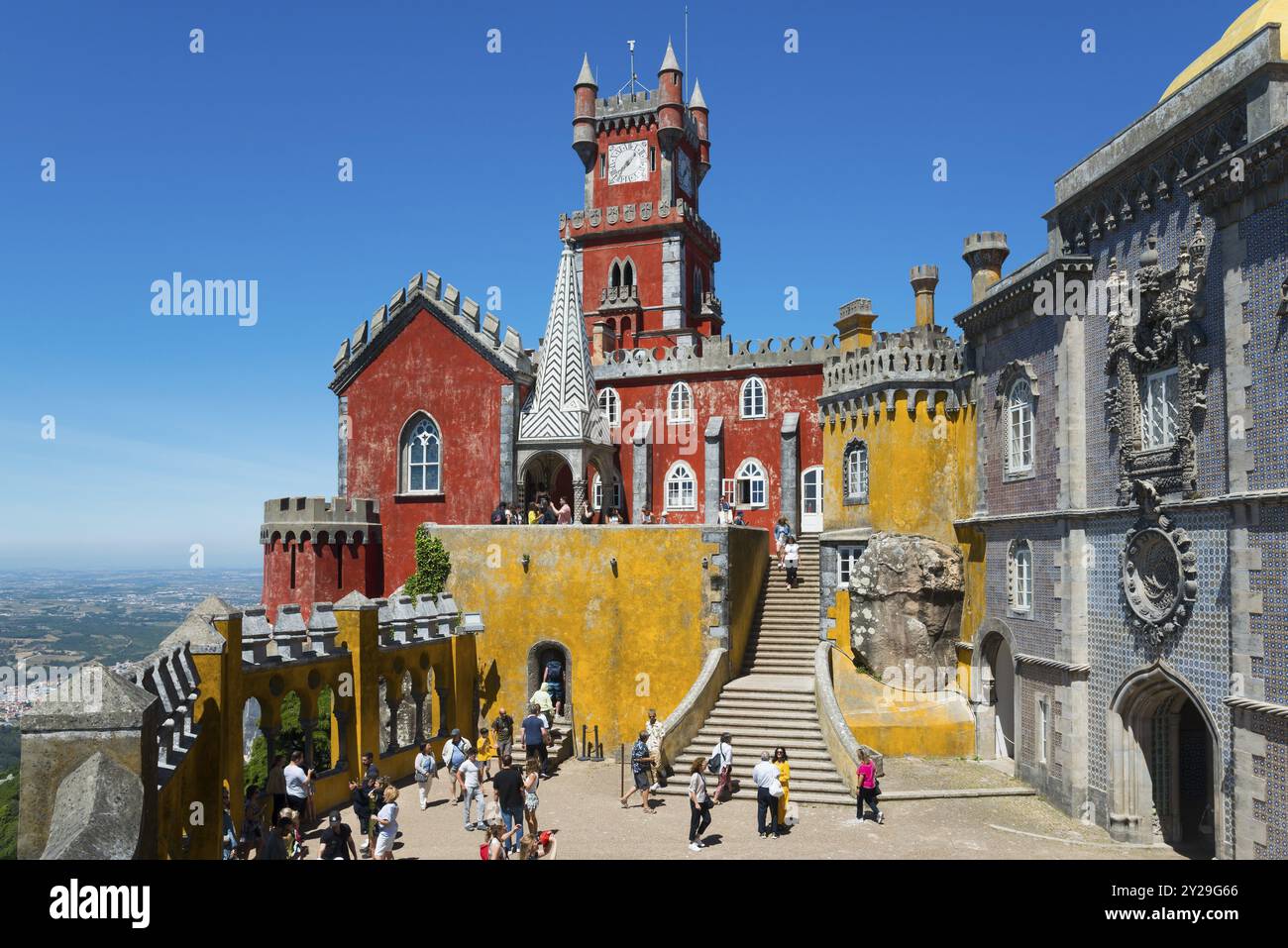 Colourful palace with red and yellow facades, many visitors and stairs ...