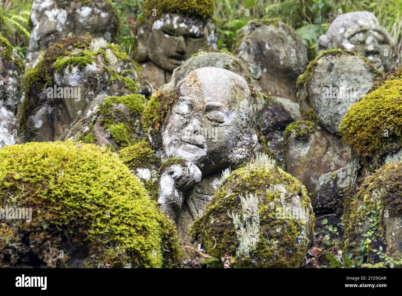 Close-up of moss-covered stone statue of rakan, the disciple of Buddha ...