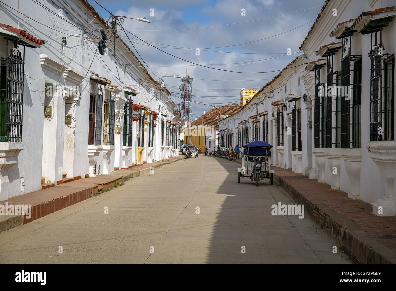 Typical street with white historic buildings in sun and shadow of Santa ...