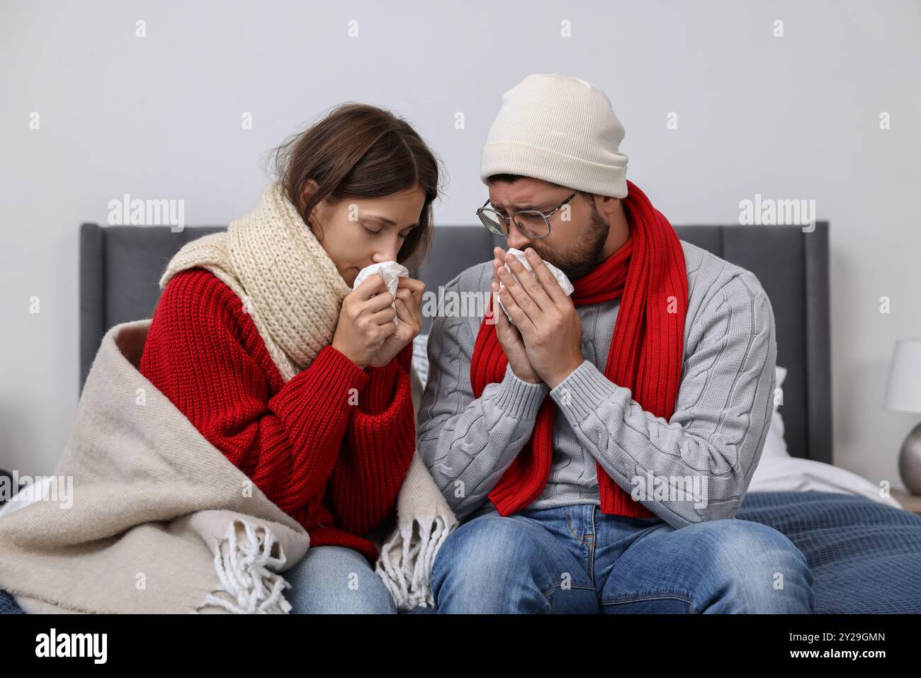 Cold symptom. Couple suffering from fever on bed at home Stock Photo ...