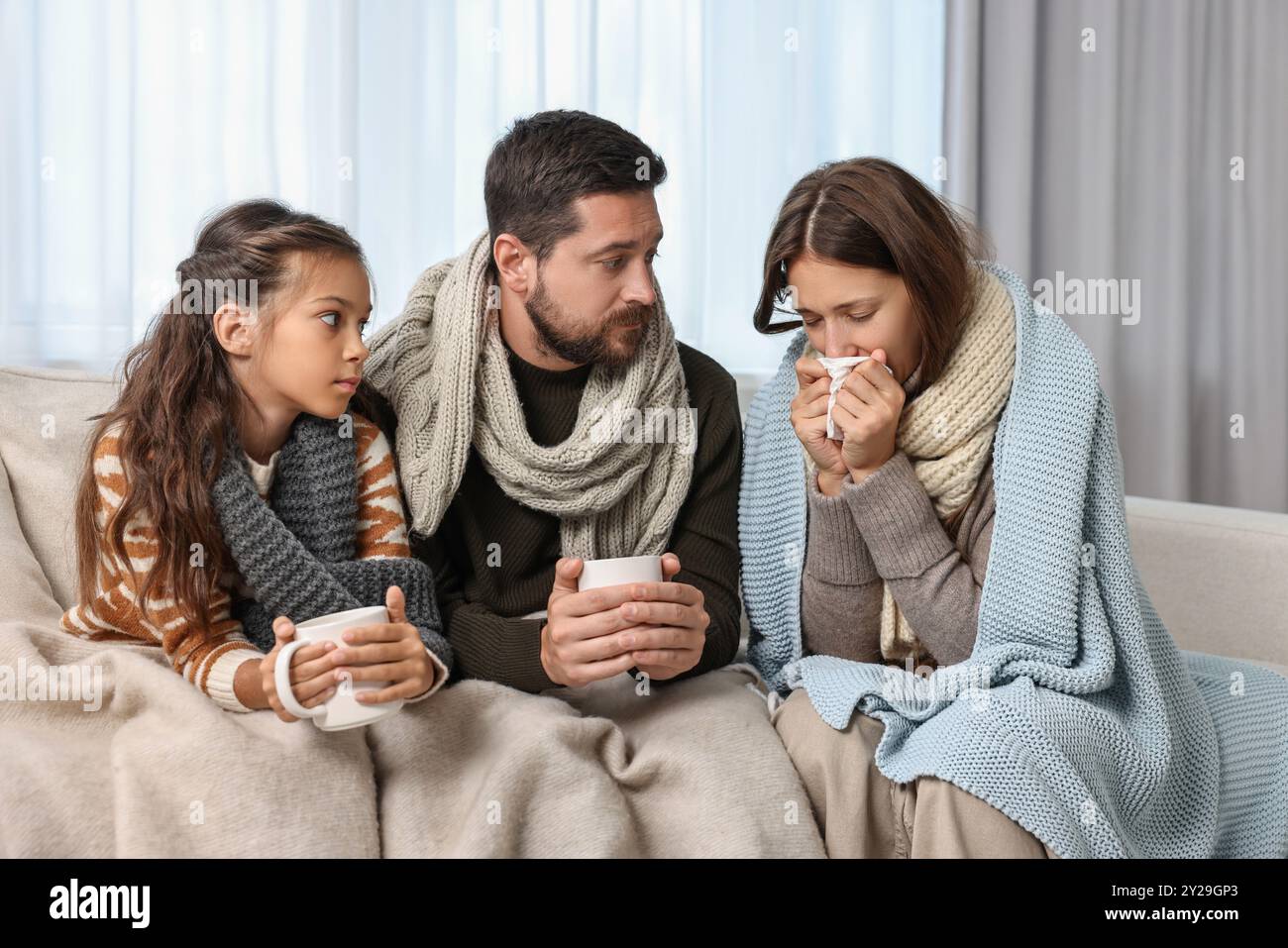 Cold symptom. Family suffering from fever on sofa at home Stock Photo ...