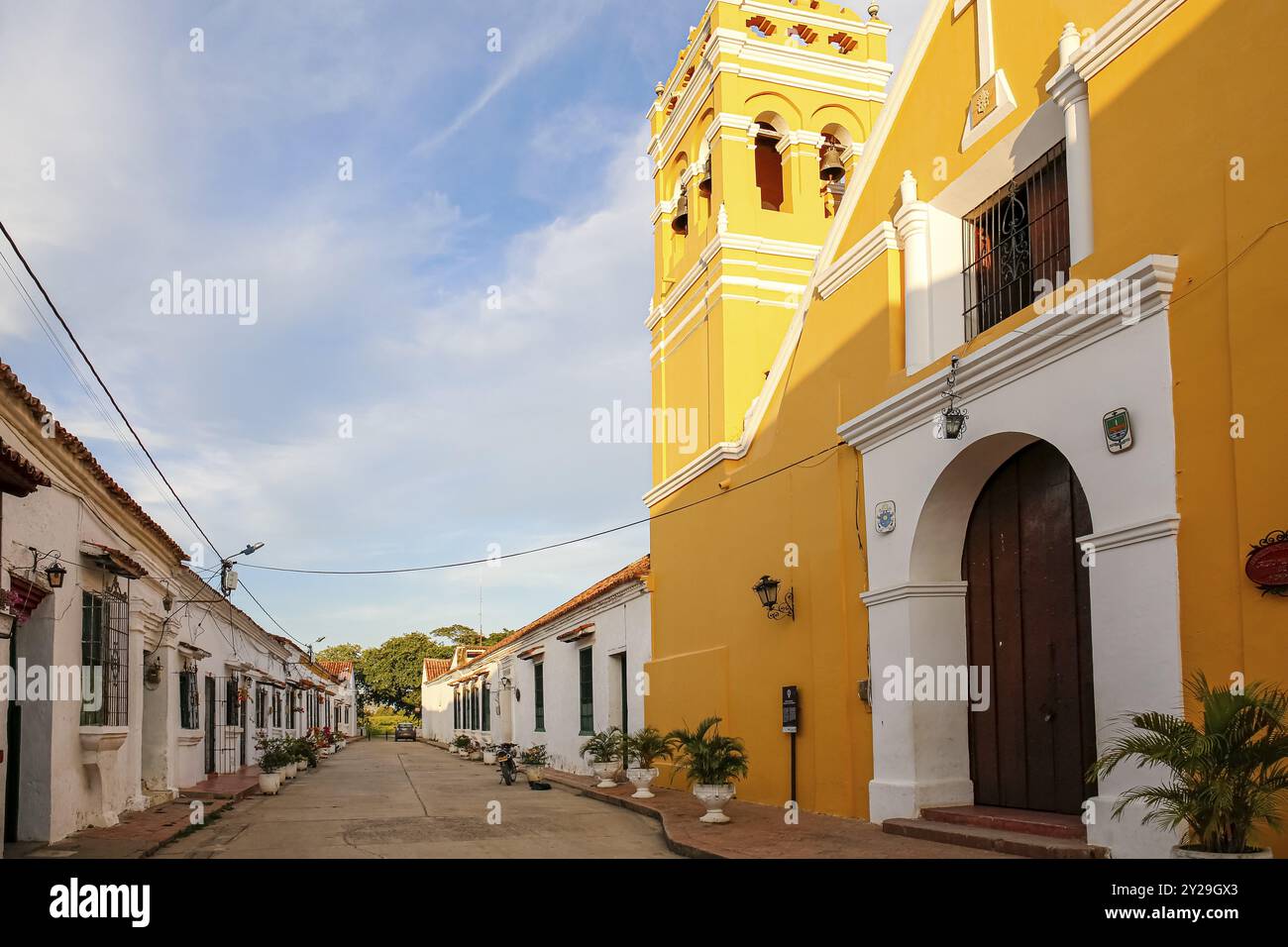 Typical street with one story buildings in sun and shadow and yellow ...