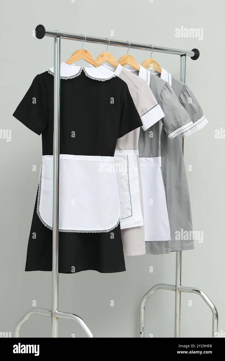 Maids' uniforms on clothing rack against grey background Stock Photo ...