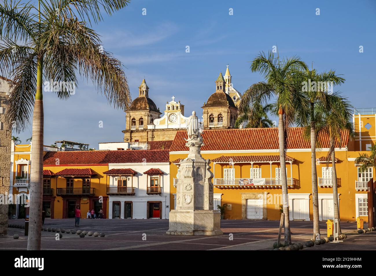 View to a plaza with a statue, historical buildings, church towers and ...