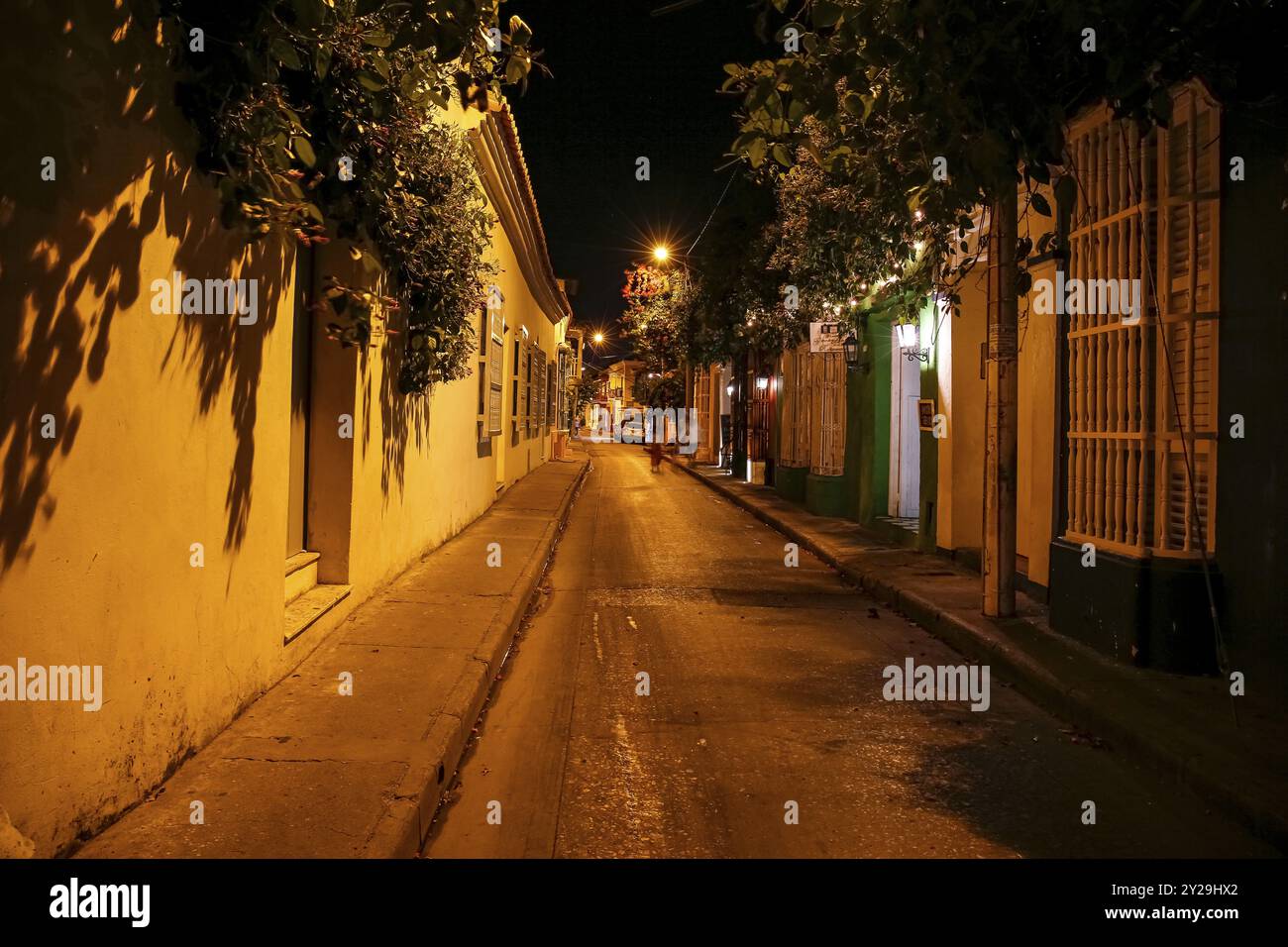 Iluminated empty street at night with colonial buildings in Cartagena ...