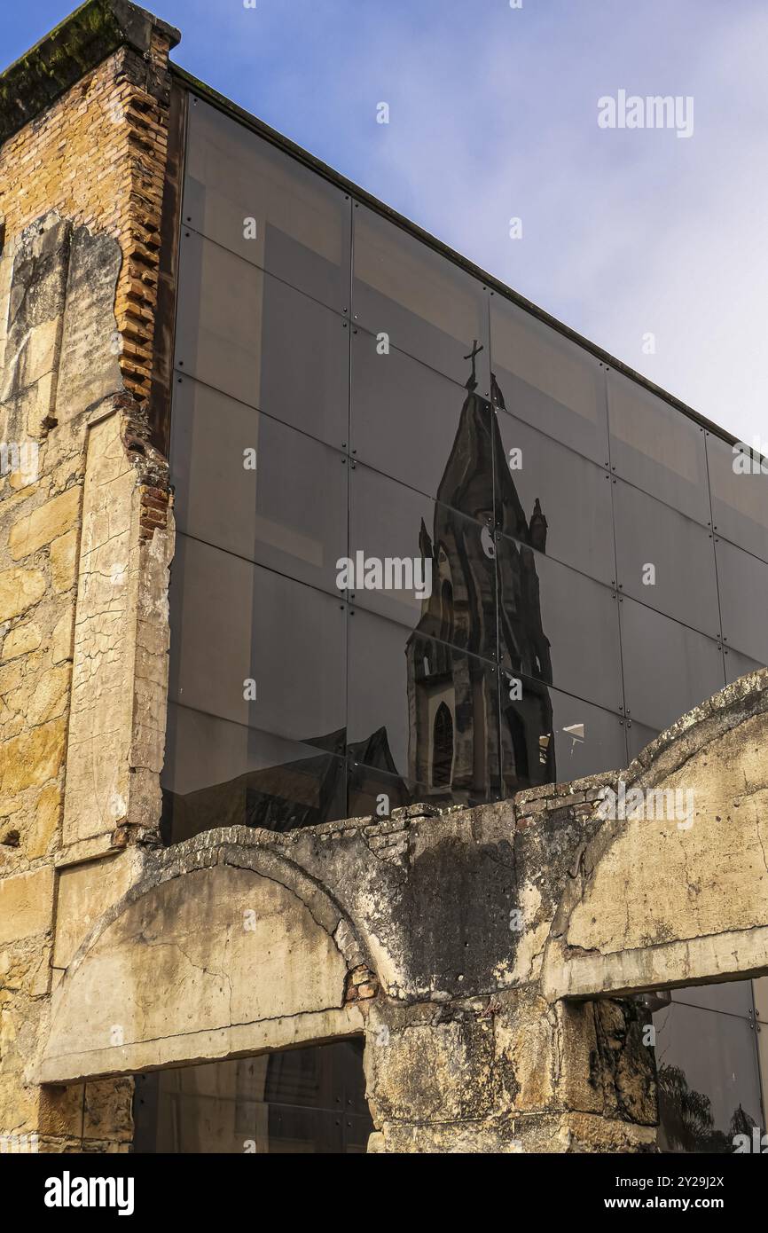 Mirror reflection of church in glass facade of the restored museum ...