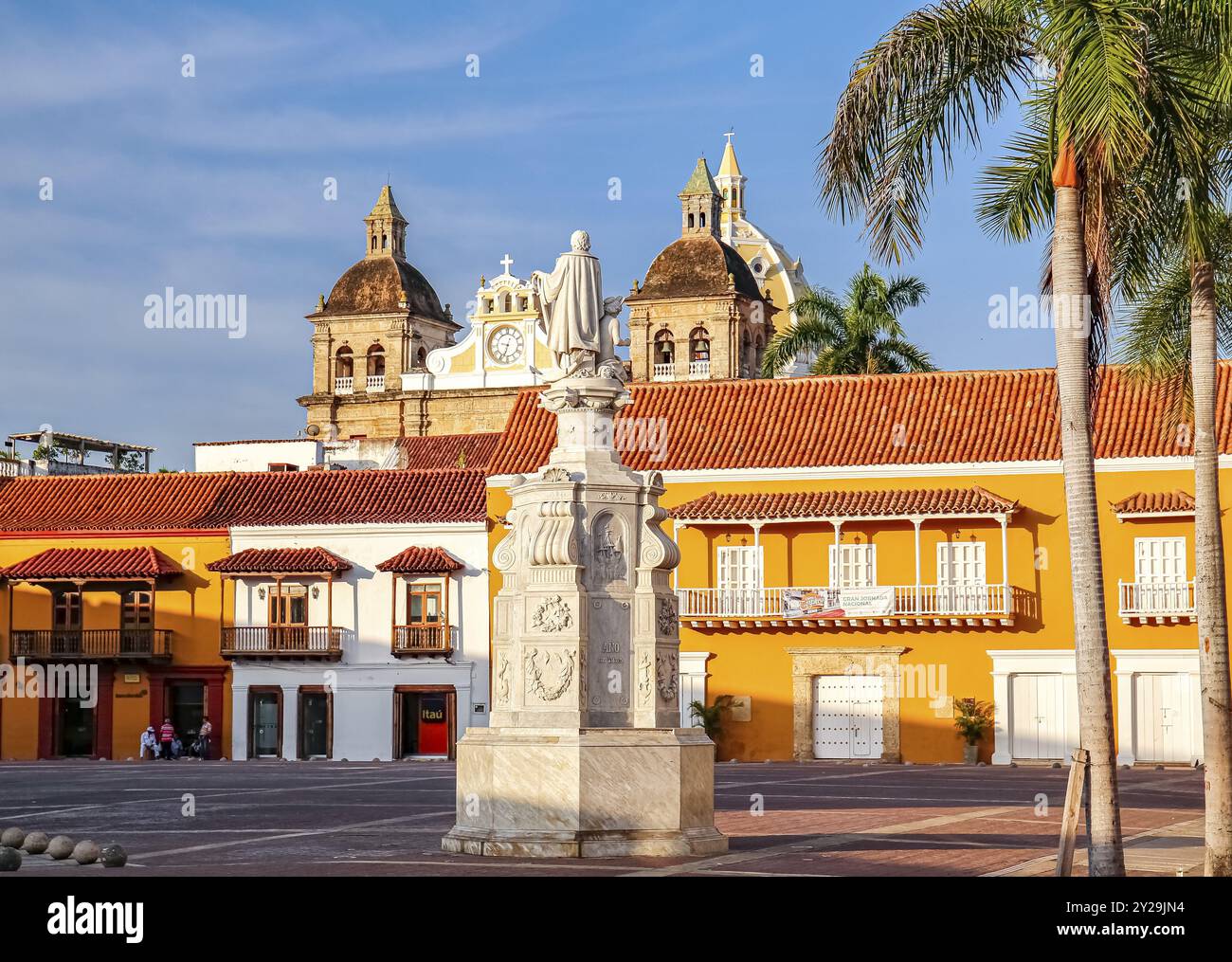 View to a plaza with a statue, historical buildings, church towers and ...