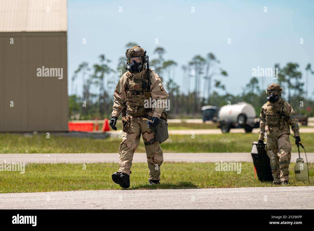 U.S. Air Force explosive ordnance disposal technicians walk towards a ...