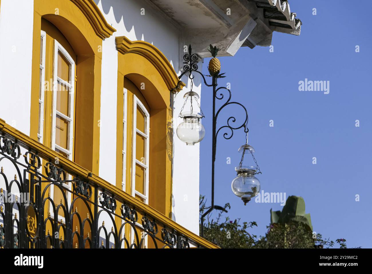 Close-up of an artful colonial house corner with two yellow framed high ...