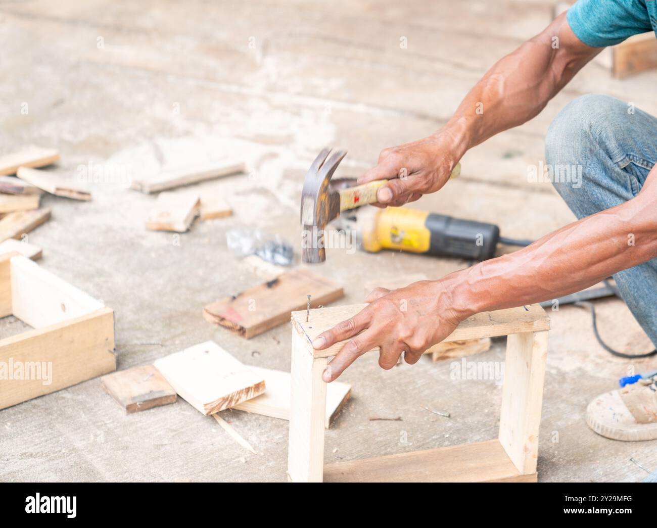 Worker hit nails on wood formwork for pour cement in an industrail ...