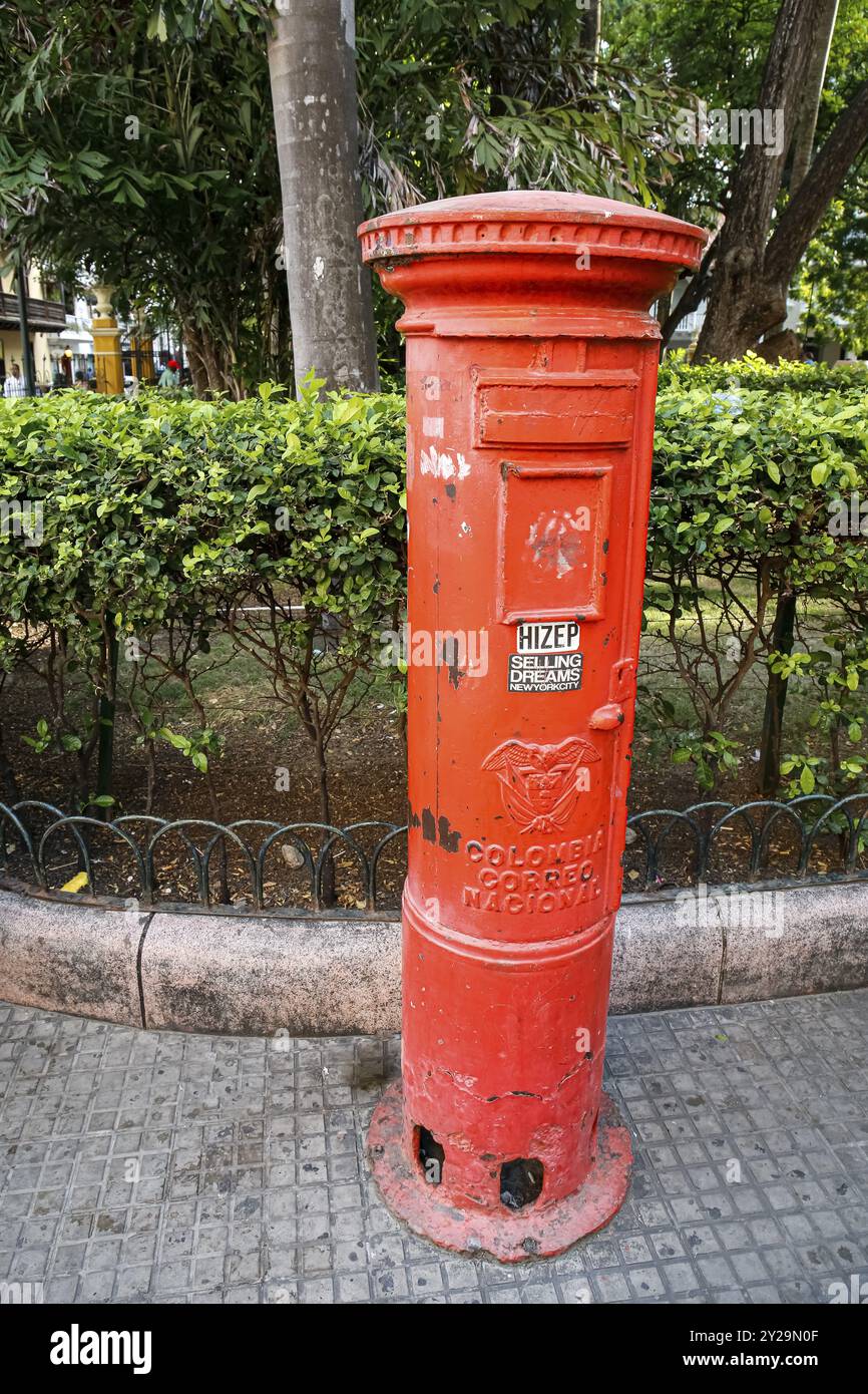 Historic red post box, green park in background, in Old Town Cartagena ...